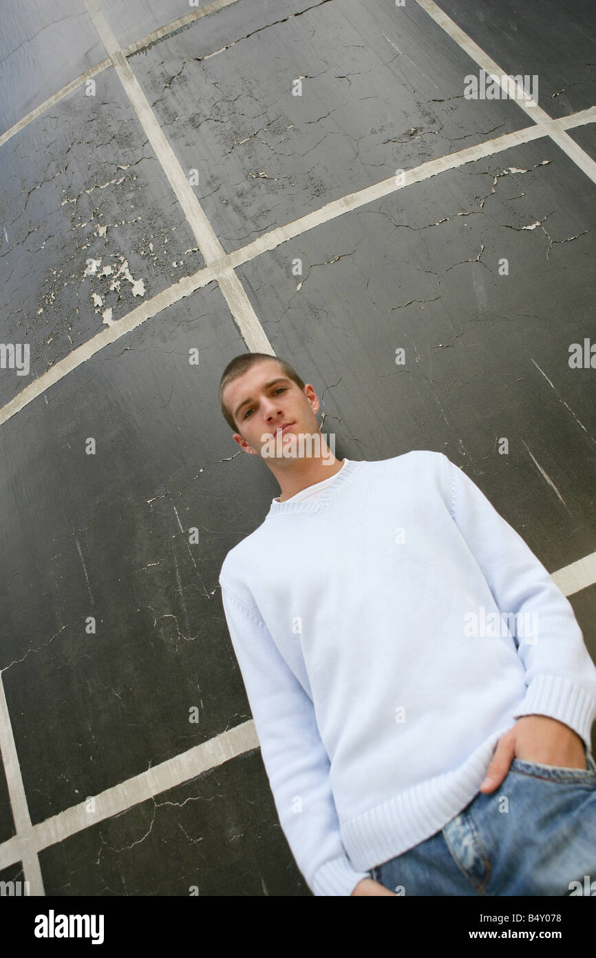 Young man standing by wall, portrait Stock Photo - Alamy