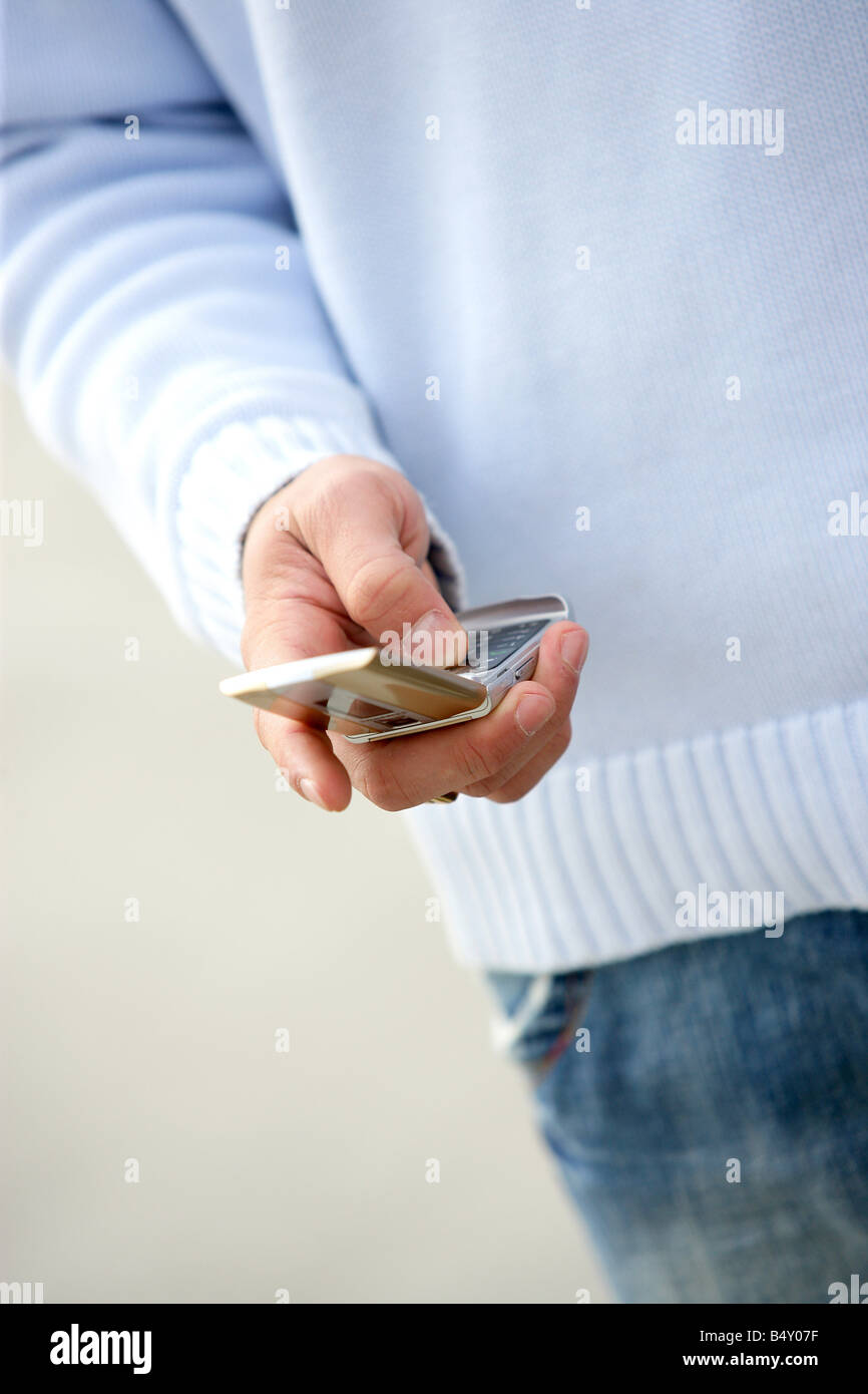 Young man holding mobile phone, close-up Stock Photo - Alamy