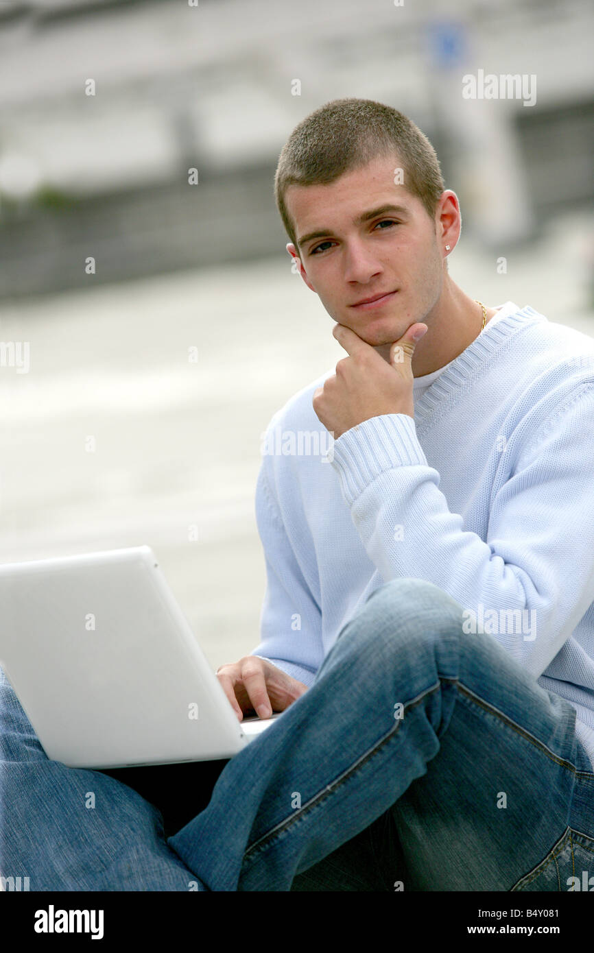 Young man sitting with laptop, portrait Stock Photo - Alamy