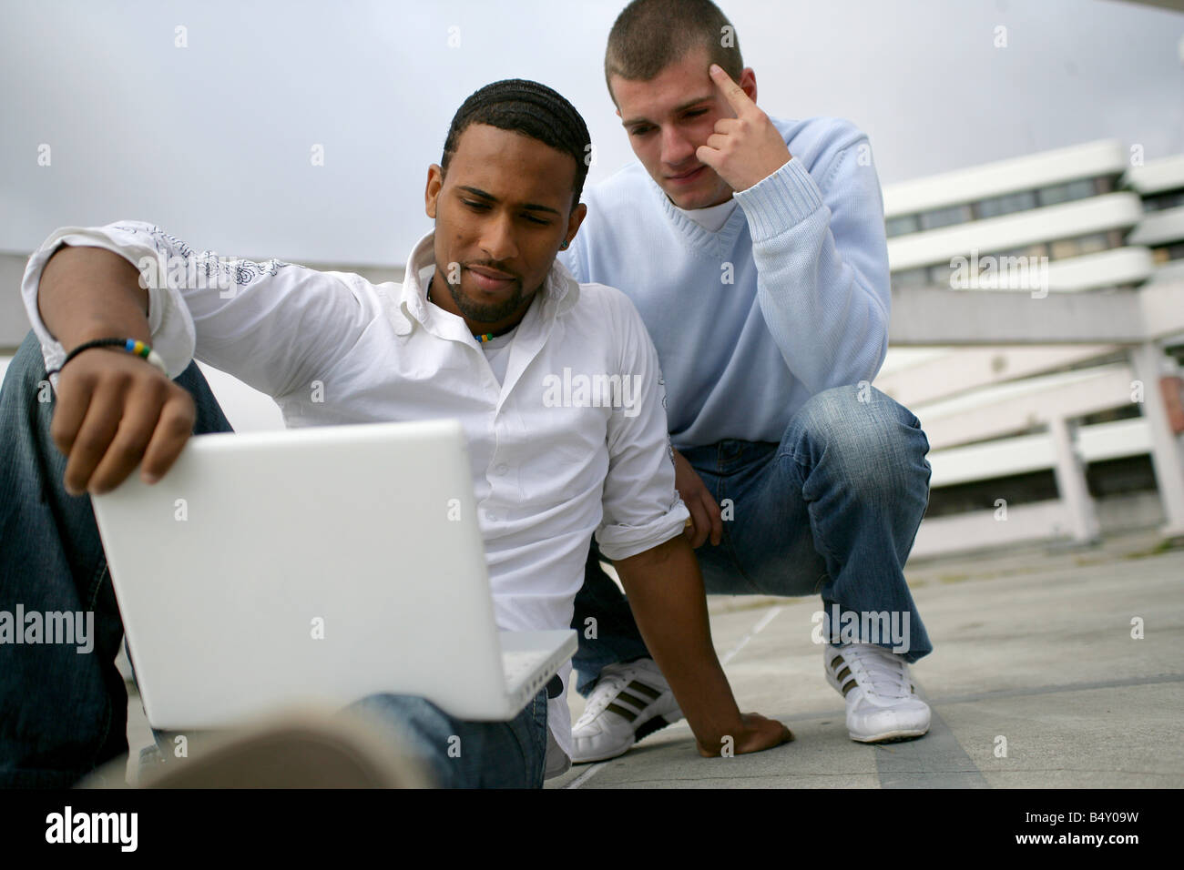 Two men outdoors with computer Stock Photo - Alamy