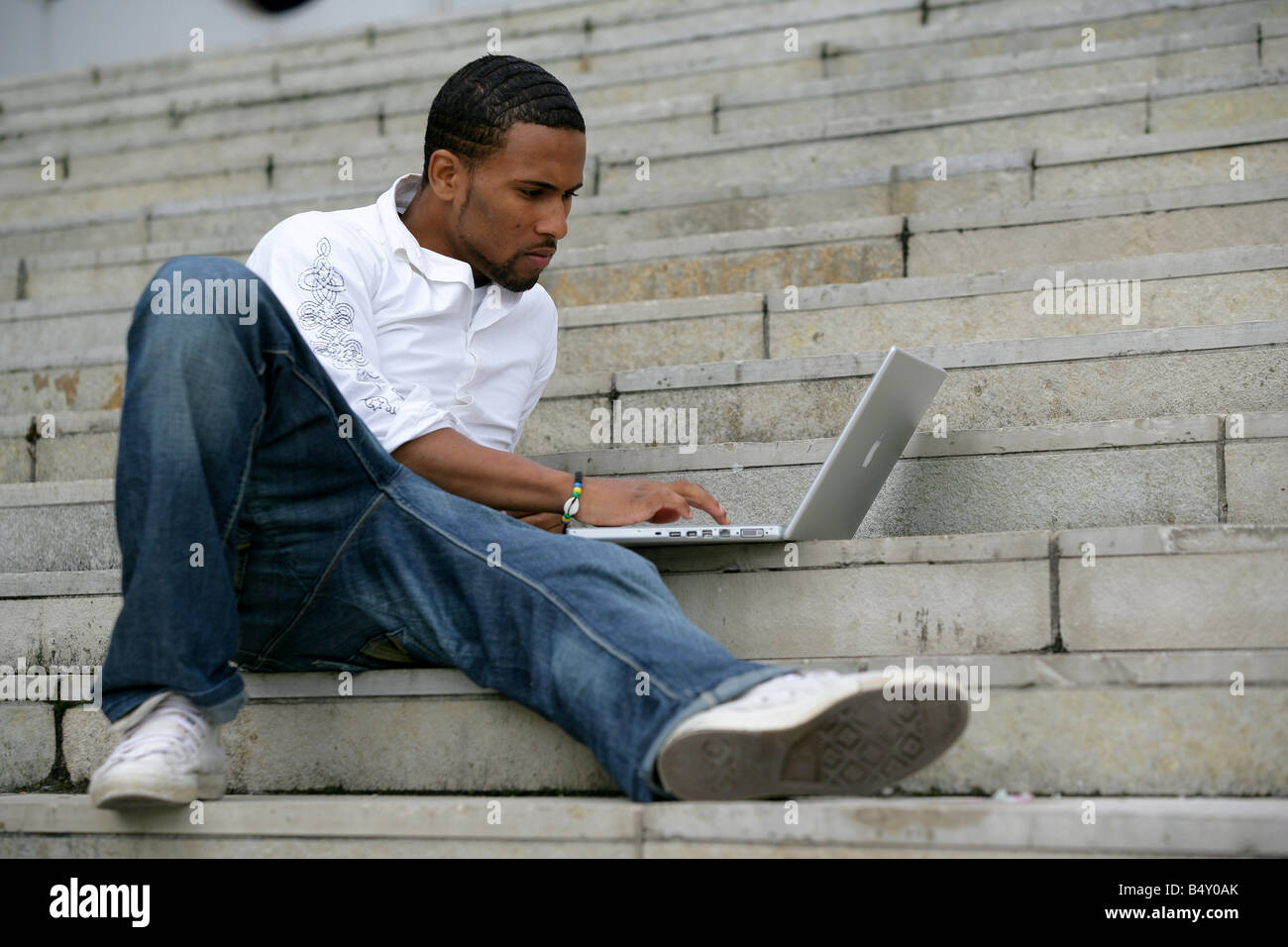 black man working on laptop in stairs Stock Photo - Alamy