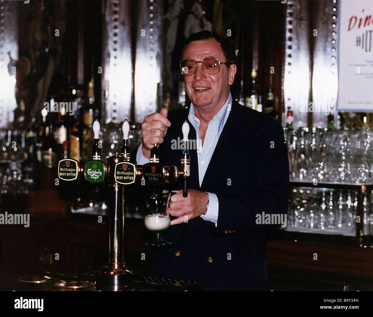 Michael Caine serving behind a bar Stock Photo - Alamy