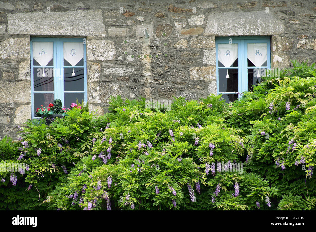 stone house facade with windows and flowers Stock Photo - Alamy