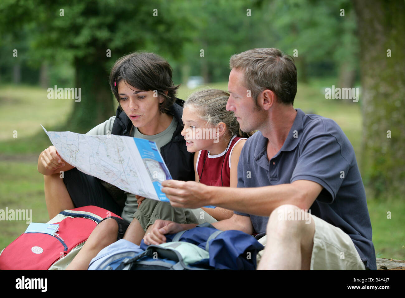 Family on hiking day looking at a map Stock Photo - Alamy