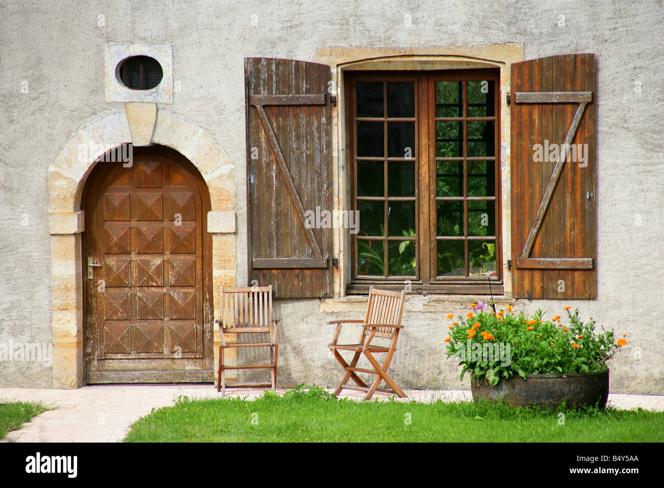 Chairs by closed door of house Stock Photo - Alamy