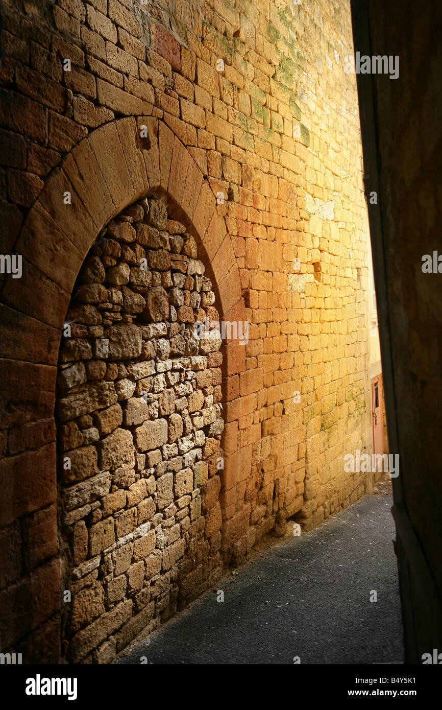 Alley by stone wall of building exterior Stock Photo - Alamy