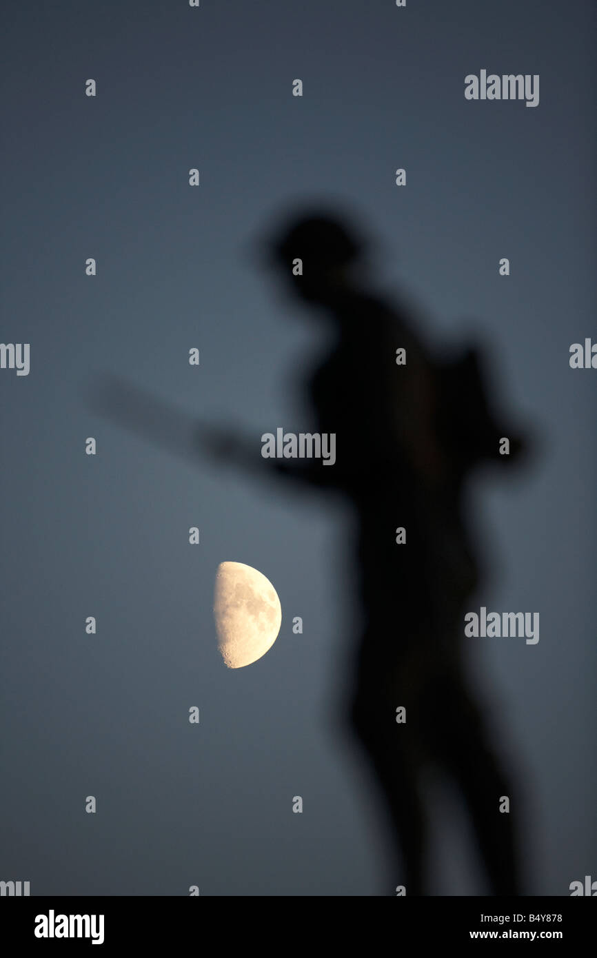 partial moon rising over war memorial statue of world war british ...