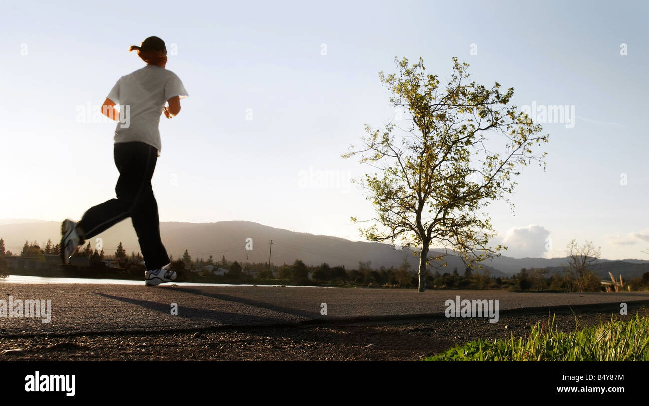 woman jogging along a river in the morning Stock Photo - Alamy