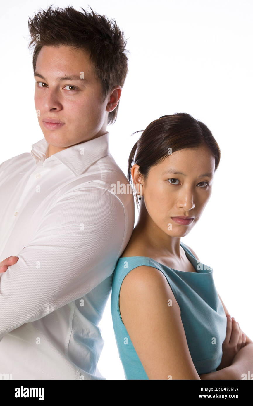 Asian couple standing back to back isolated against white background ...