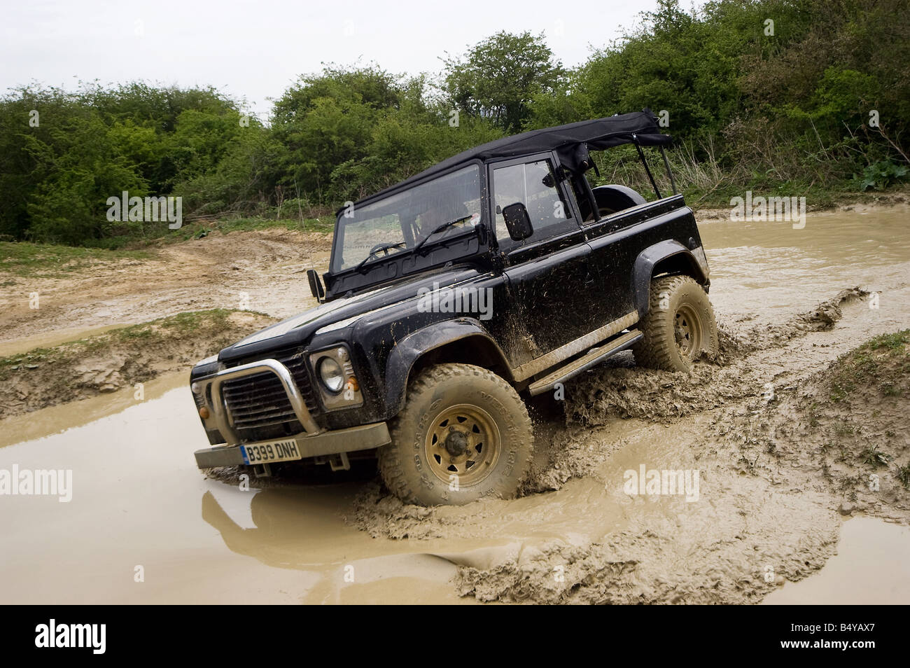 Land Rover defender driving off road through water Stock Photo - Alamy