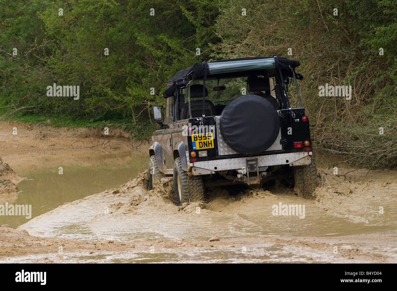 Land Rover defender driving off road through water Stock Photo - Alamy