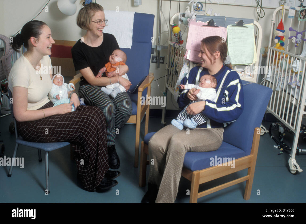 group of three young mums with their prematures babies socialising in ...