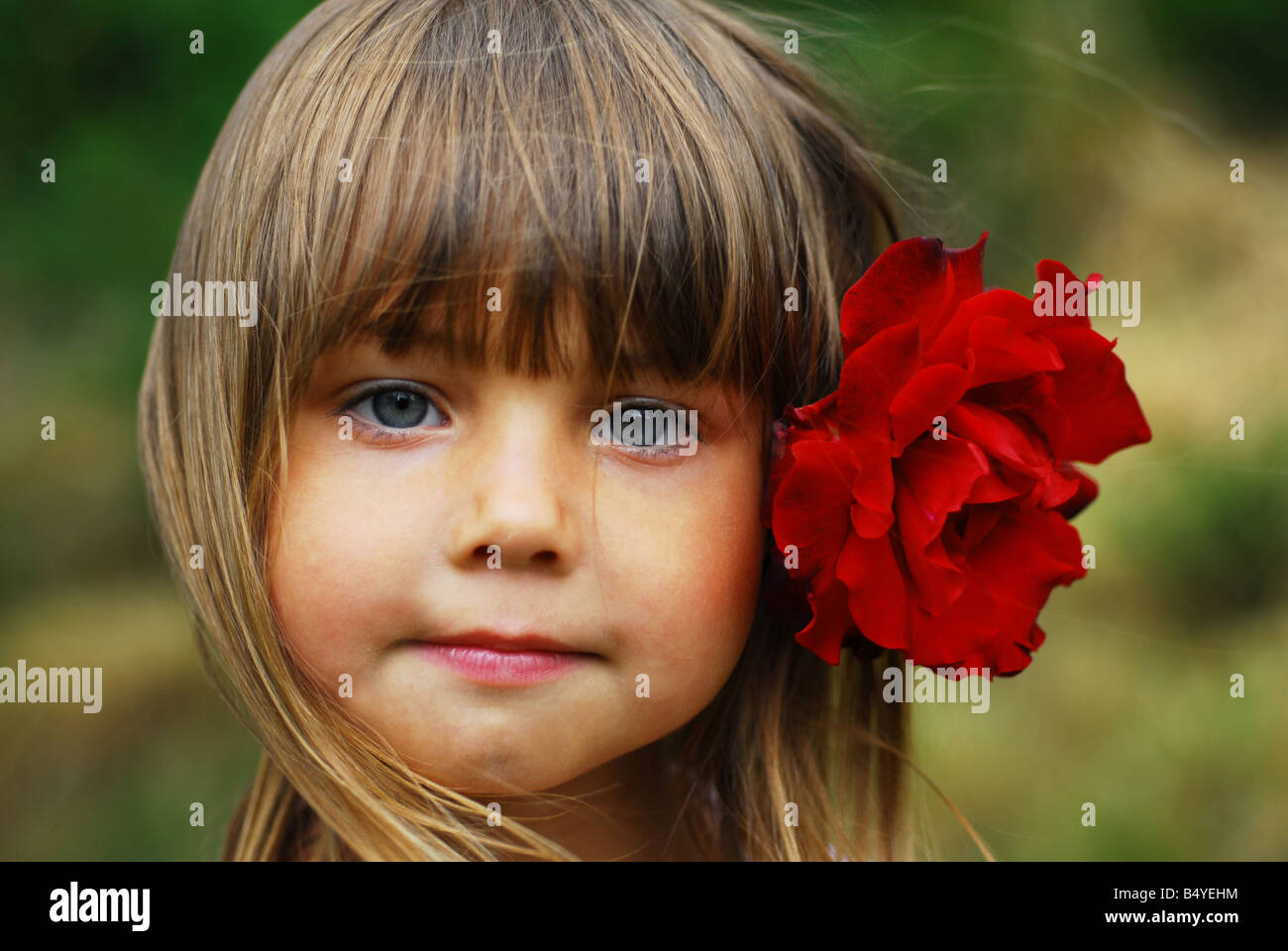 Beautiful little girl with rose in her hair Stock Photo - Alamy