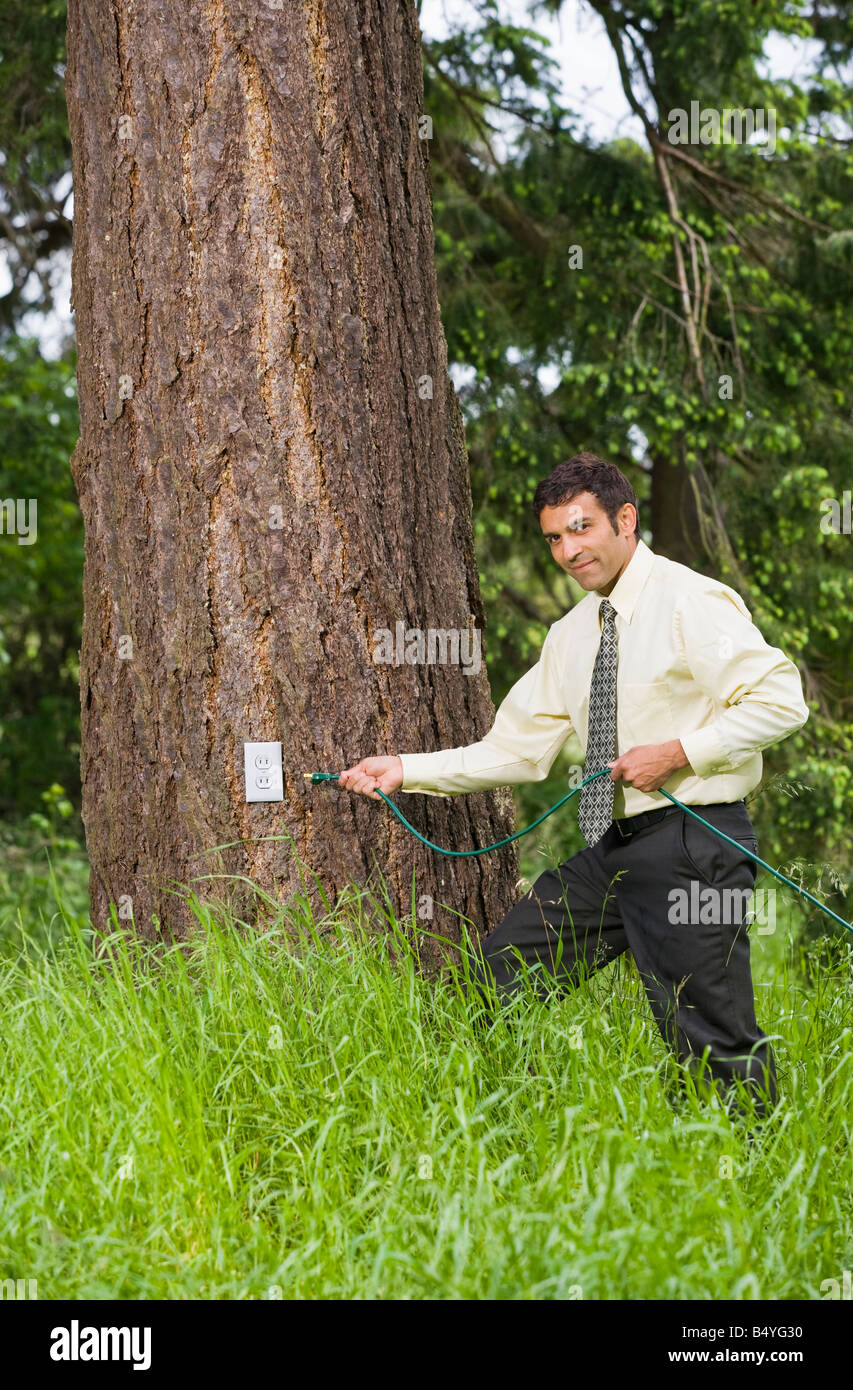 A mixed race businessman holding an electrical extension cord about to ...