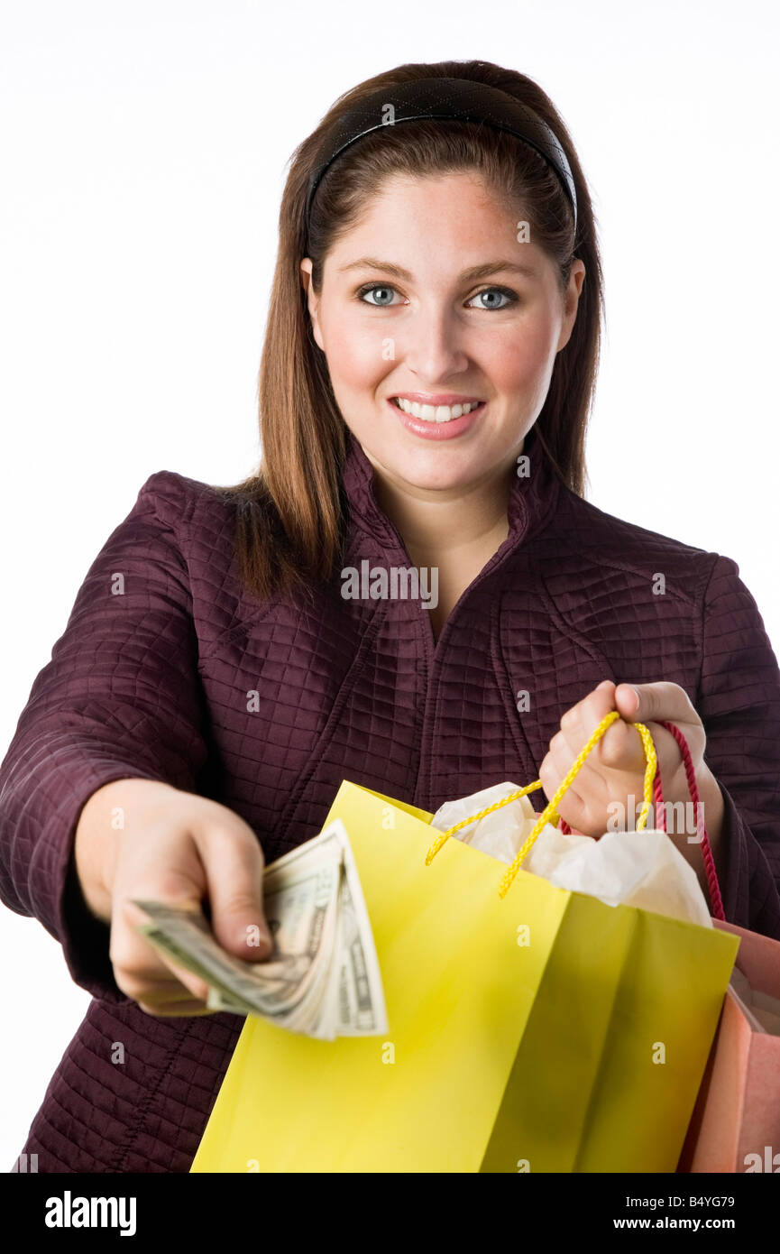 Woman holding shopping bag and passing money Stock Photo - Alamy