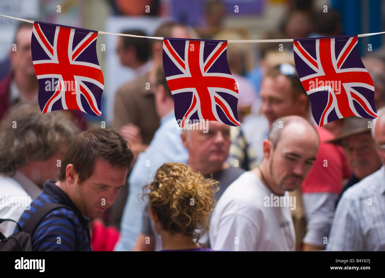 Union Jack flags with crowd of people in Market Hall during Abergavenny ...