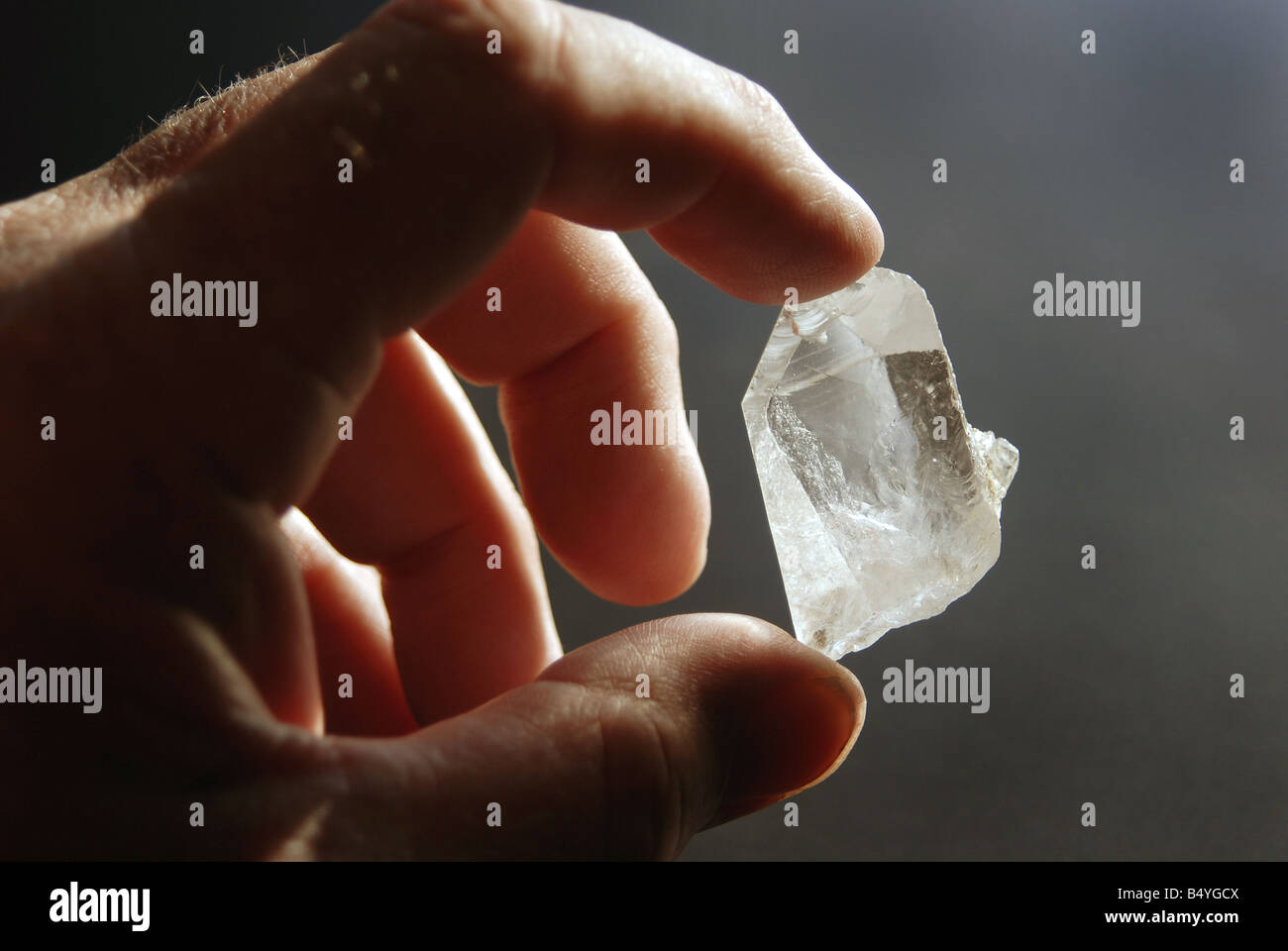 A hand holding a piece of quartz Stock Photo - Alamy