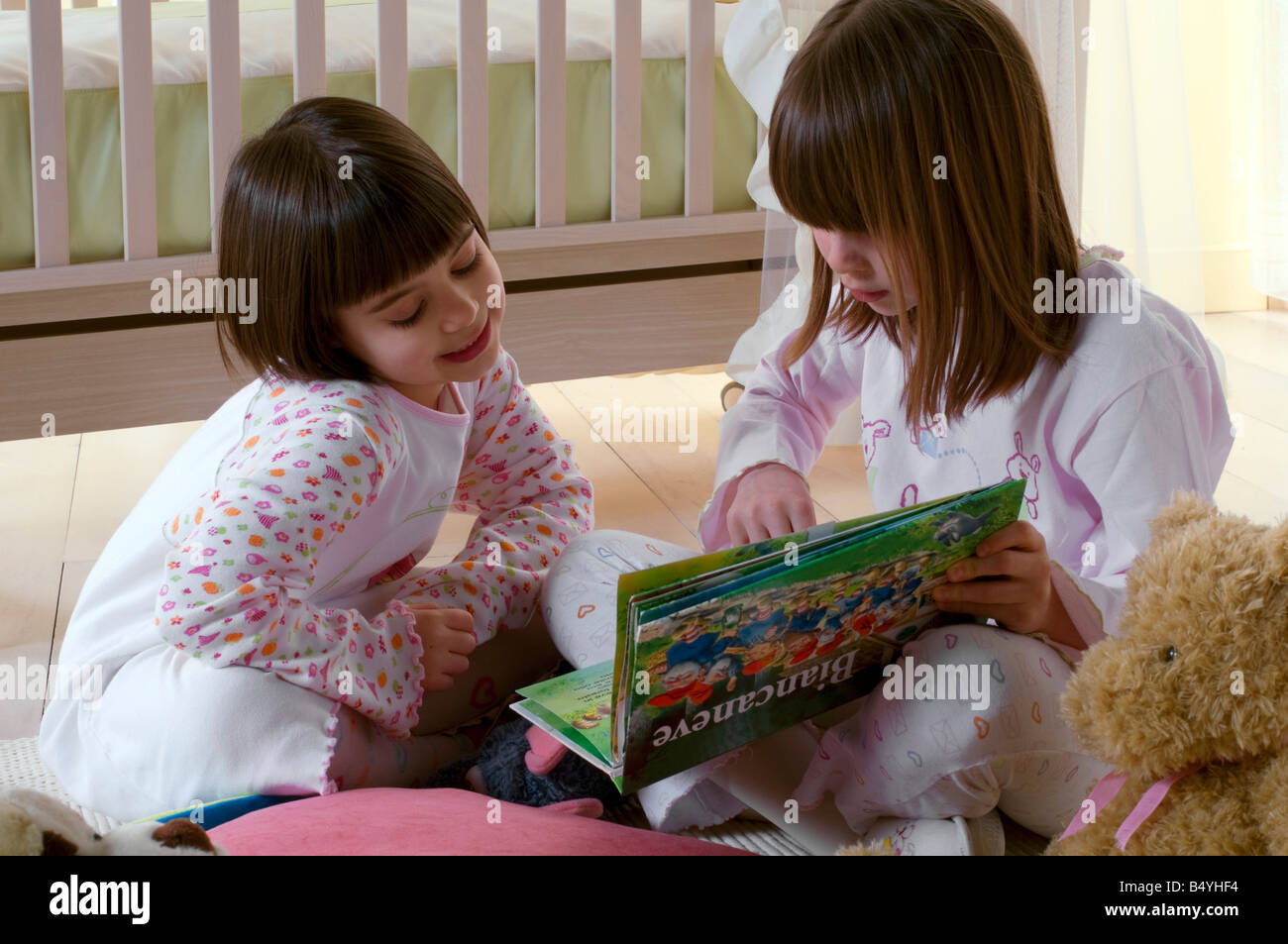 little girls reading a book, pyjama Stock Photo - Alamy
