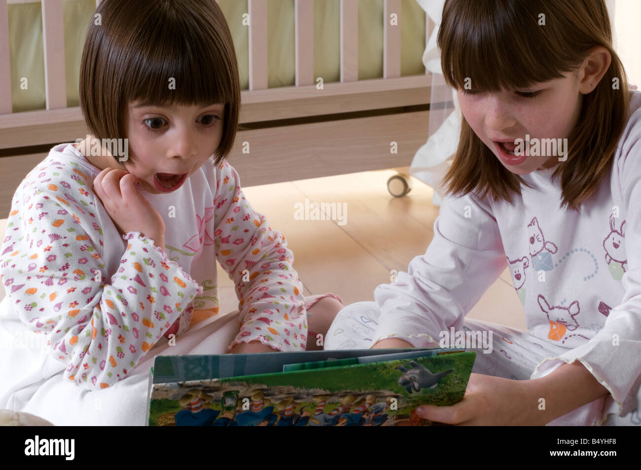 little girls reading a book, pyjama Stock Photo - Alamy