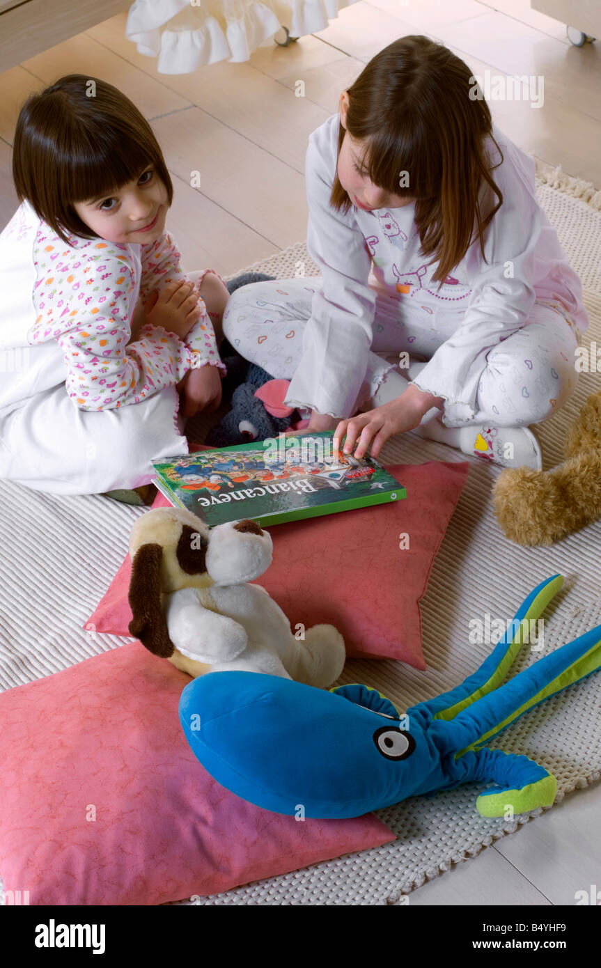 little girls reading a book, pyjama Stock Photo - Alamy