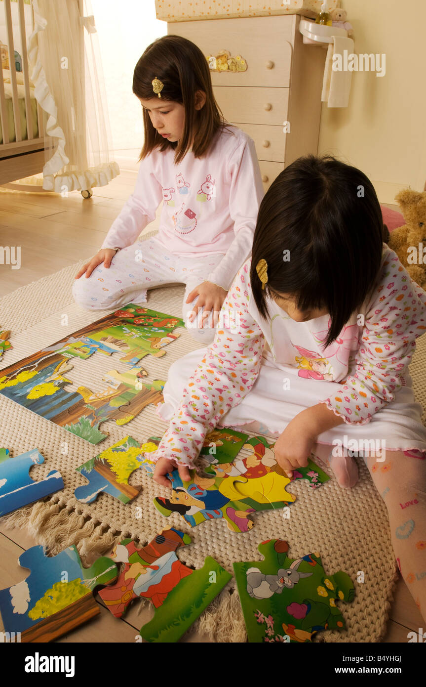little girls playing with a puzzle Stock Photo - Alamy
