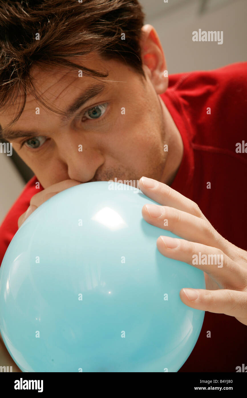 man inflating a balloon Stock Photo - Alamy