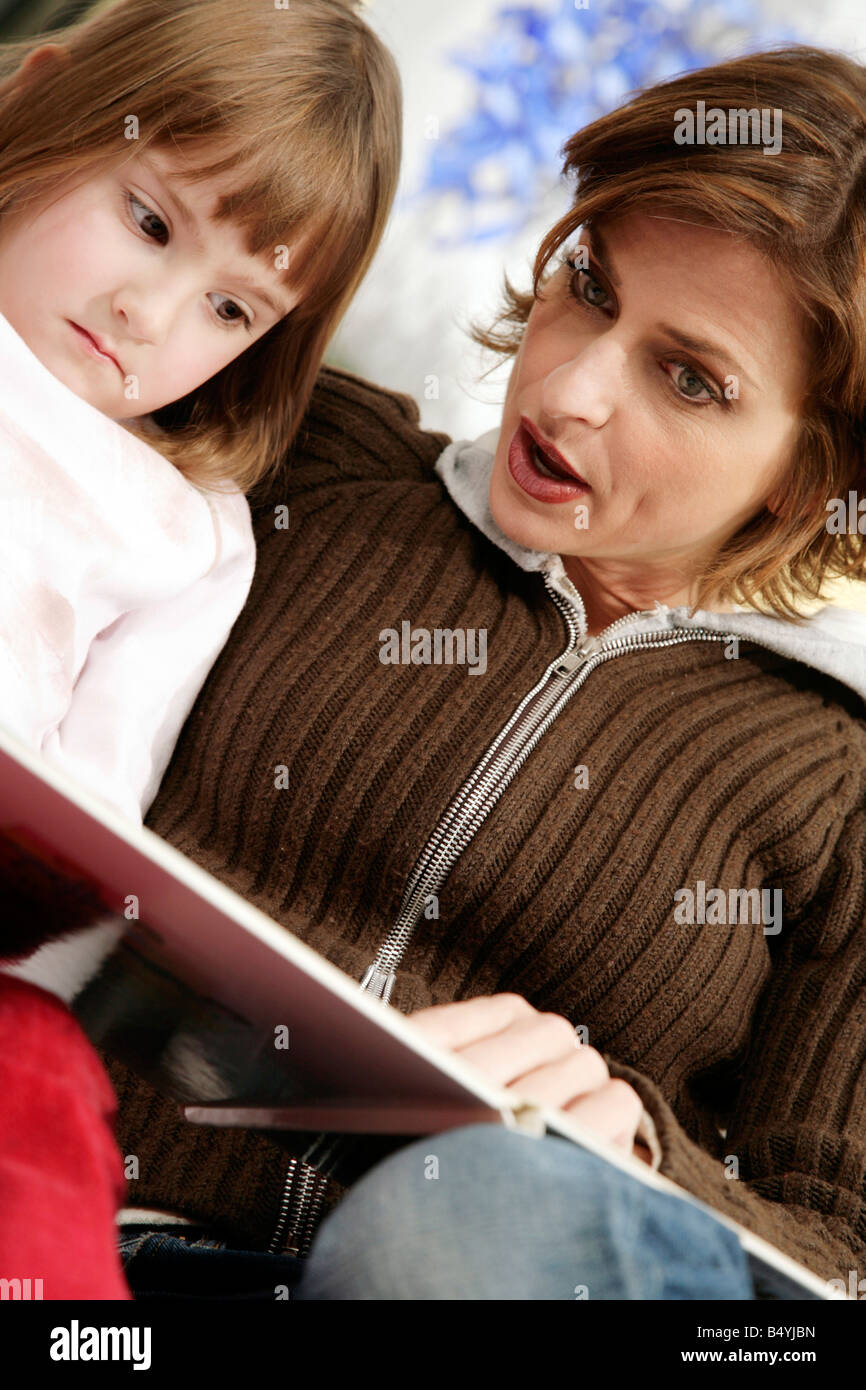 woman and little girl reading a book Stock Photo - Alamy