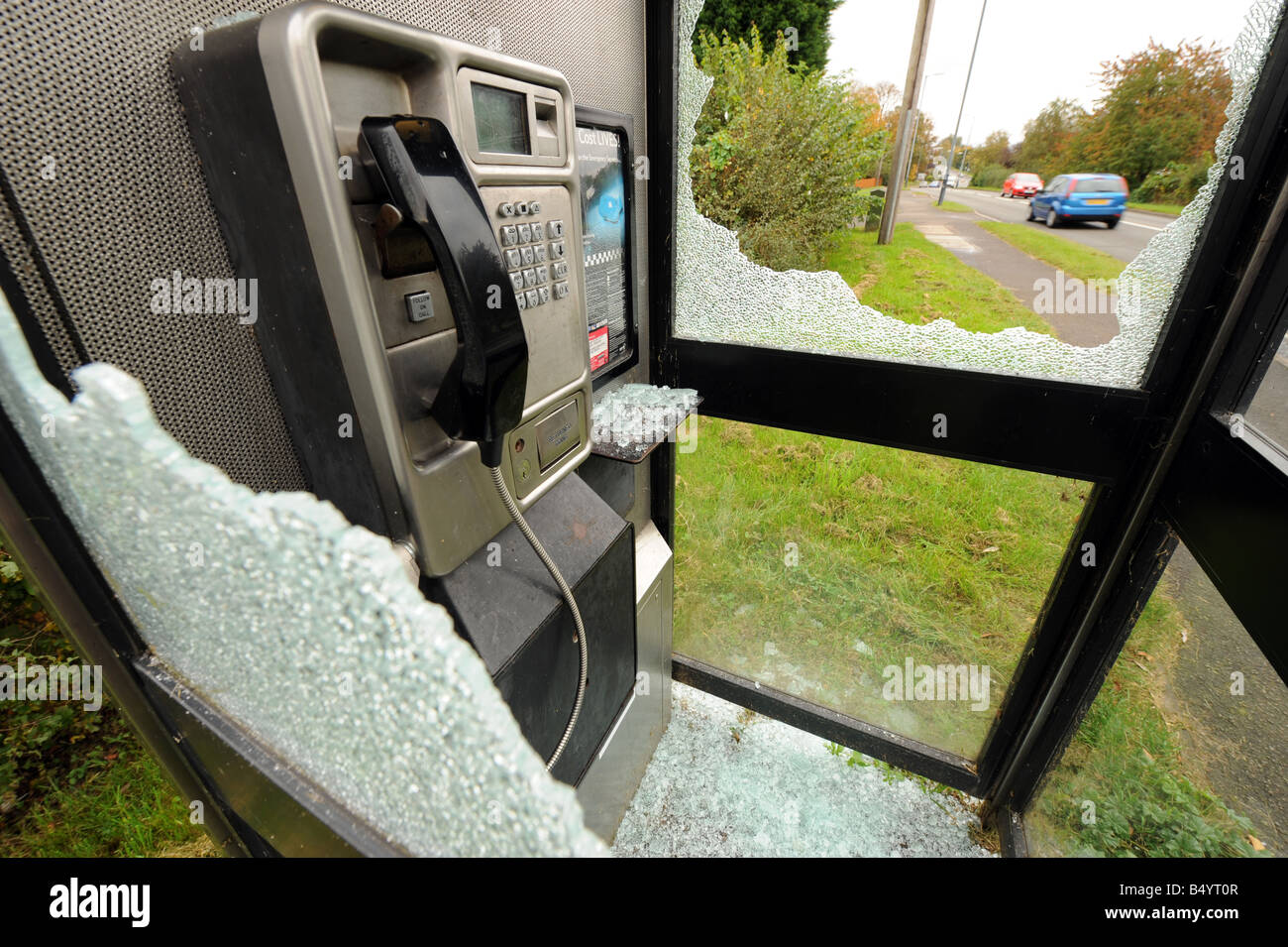 Smashed glass litters the interior of a British Telecom phone box after ...