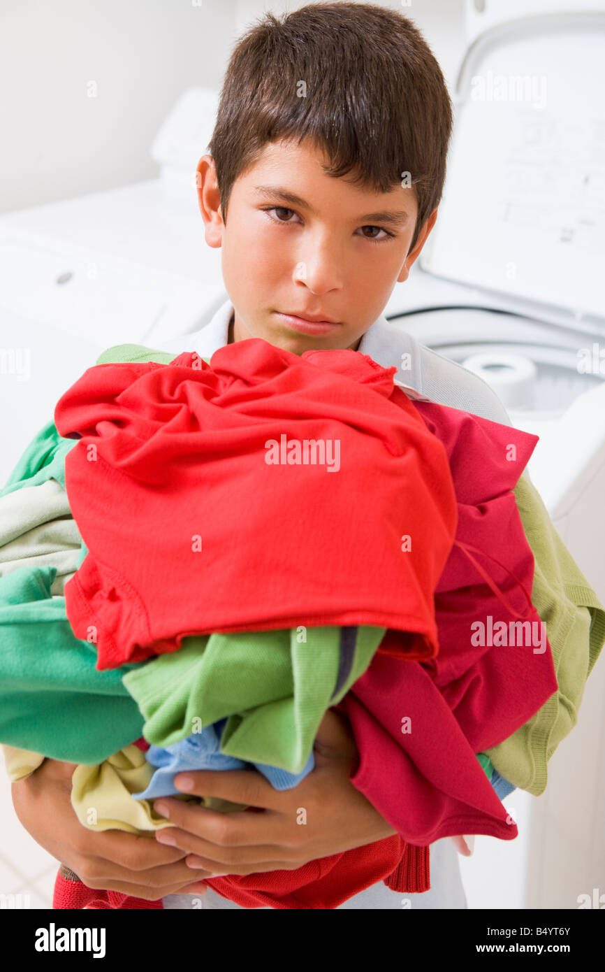 Young Boy Holding A Pile Of Laundry Stock Photo - Alamy