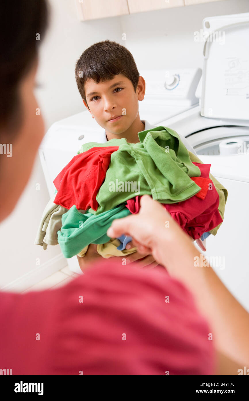 Young Boy Holding A Pile Of Laundry Stock Photo - Alamy