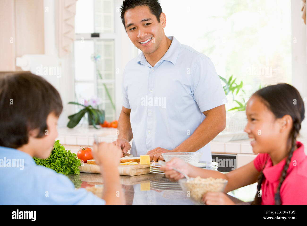 Children Having Breakfast While Dad Prepares Food Stock Photo - Alamy