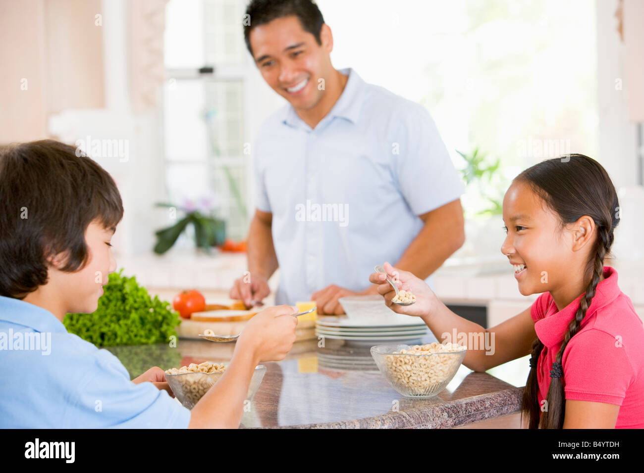 Children Having Breakfast While Dad Prepares Food Stock Photo - Alamy