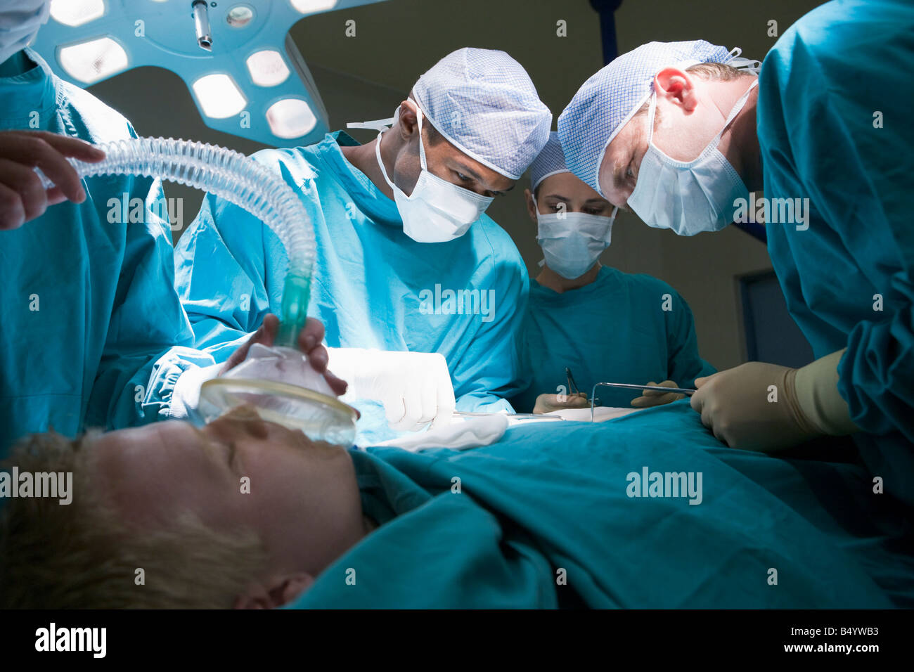 Three Surgeons Operating On A Patient Stock Photo - Alamy