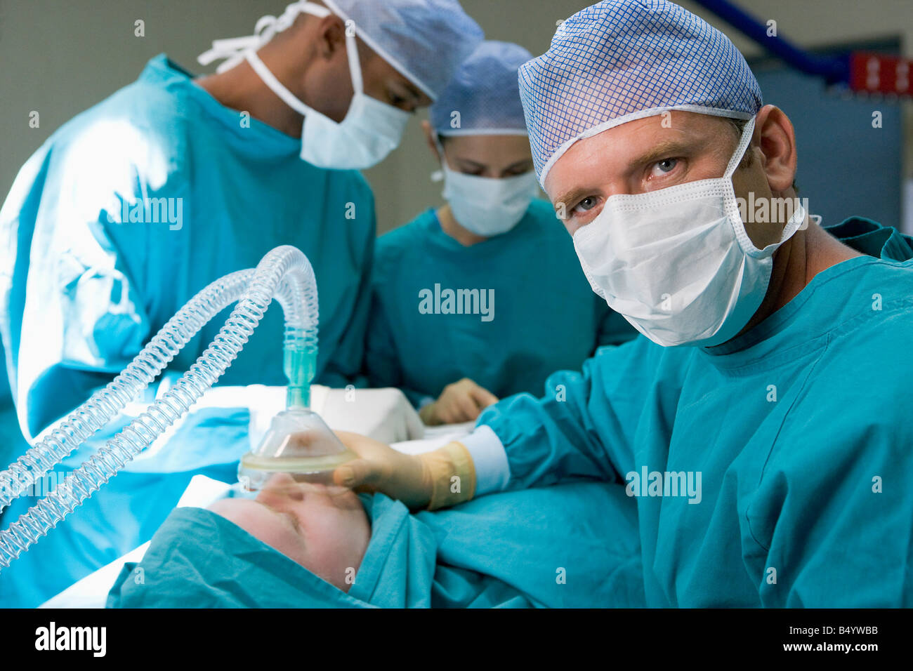 Three Surgeons Operating On A Patient Stock Photo - Alamy