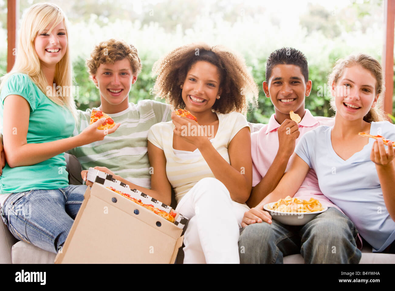 Group Of Teenagers Sitting On A Couch Eating Pizza Stock Photo - Alamy