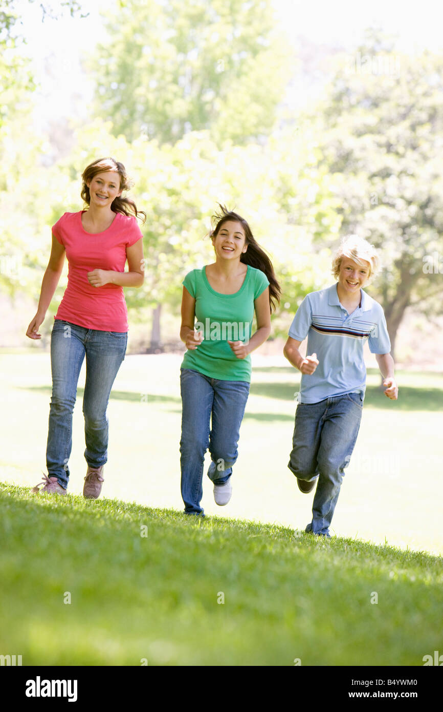 Teenagers Running Through Park Stock Photo - Alamy