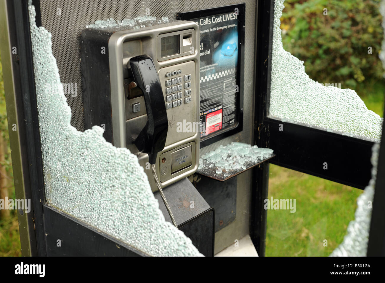 Smashed glass litters the interior of a British Telecom phone box after ...