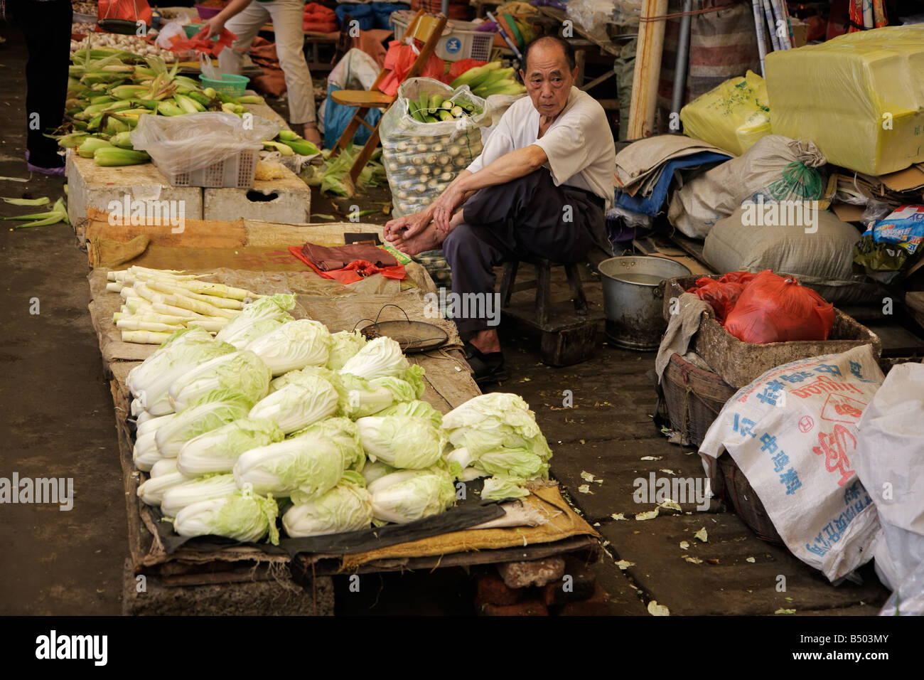 Old Chinese man selling his vegetables on a street market, Yangshuo ...