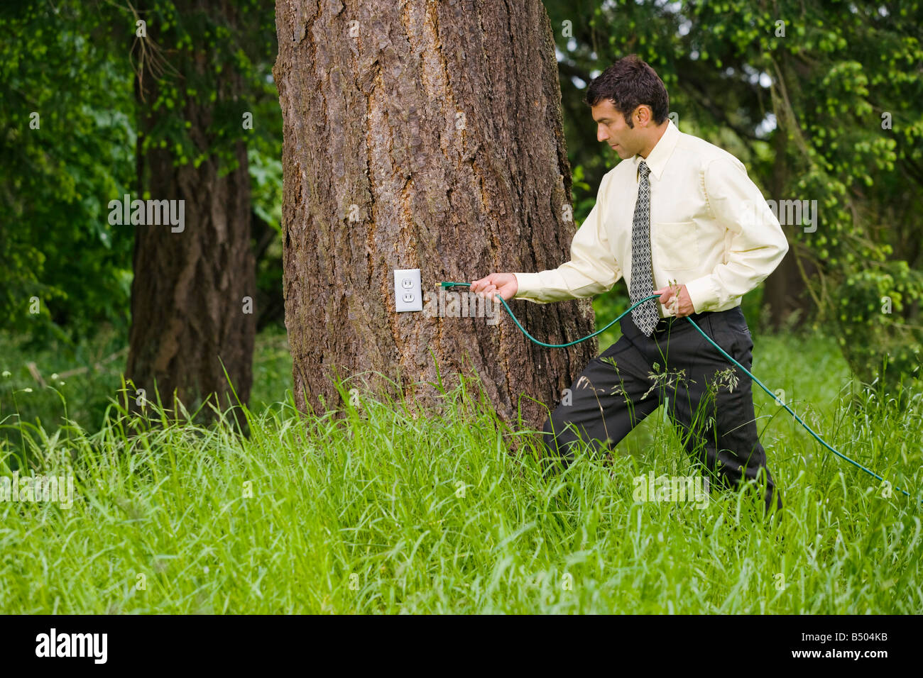 A mixed race businessman holding an electrical extension cord about to ...