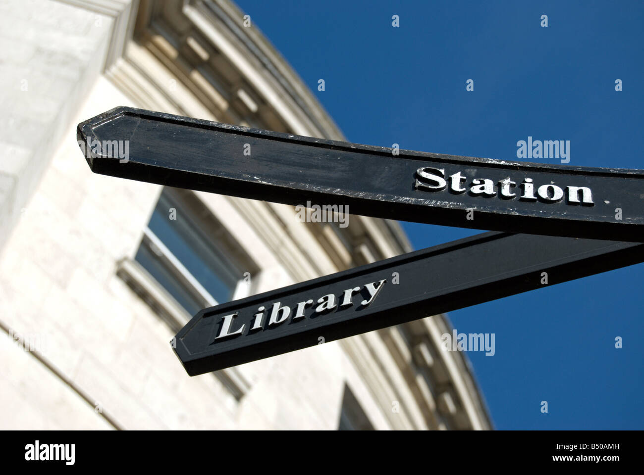 black signs with white lettering giving directions to the local library ...