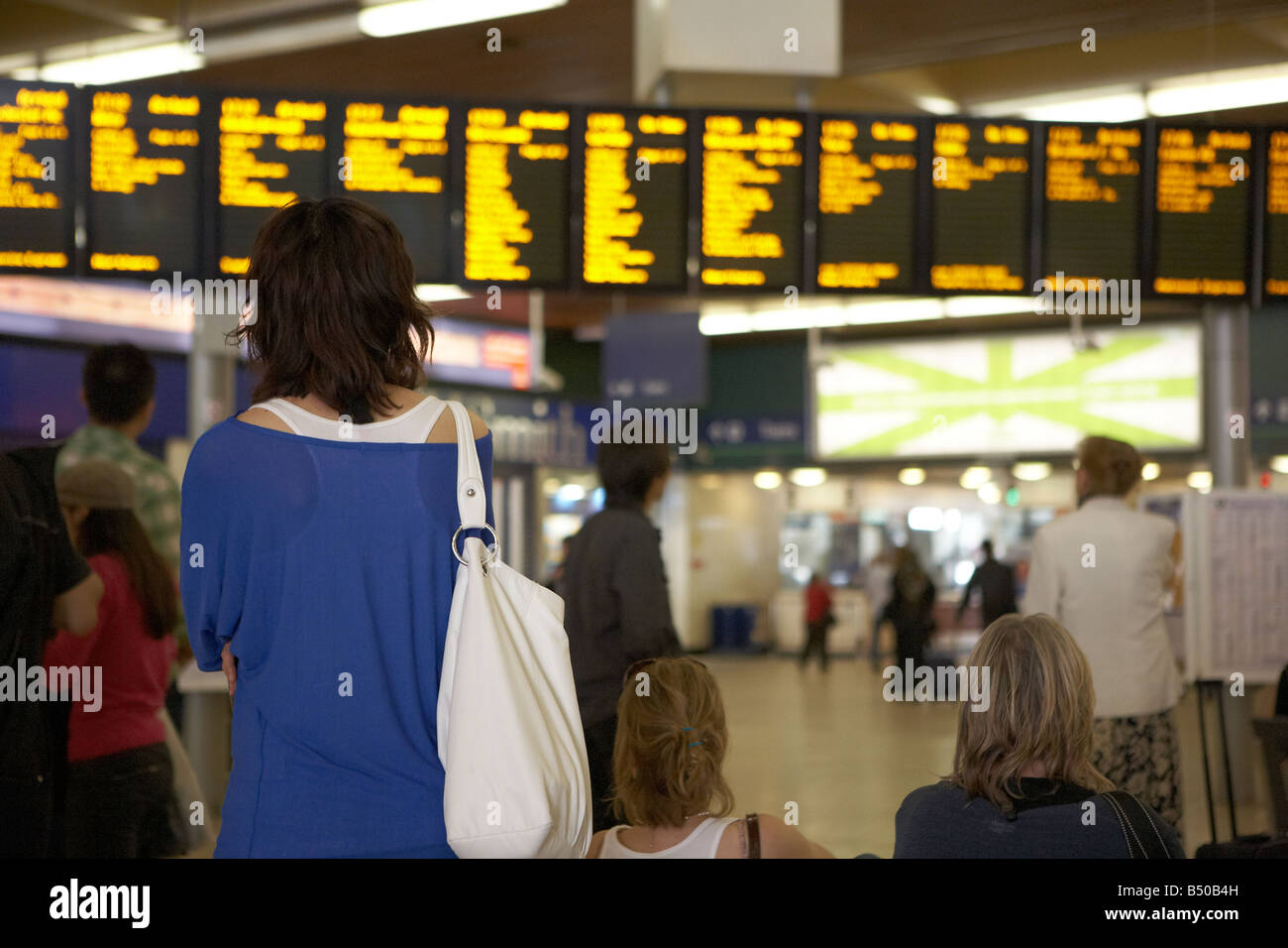 Girl checking out train departures Stock Photo - Alamy