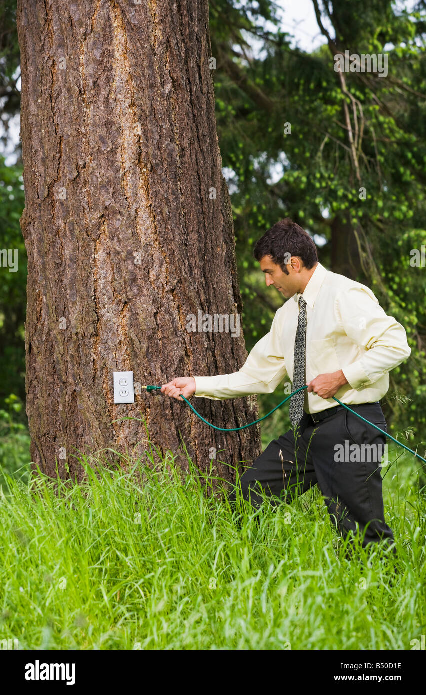 A mixed race businessman holding an electrical extension cord about to ...