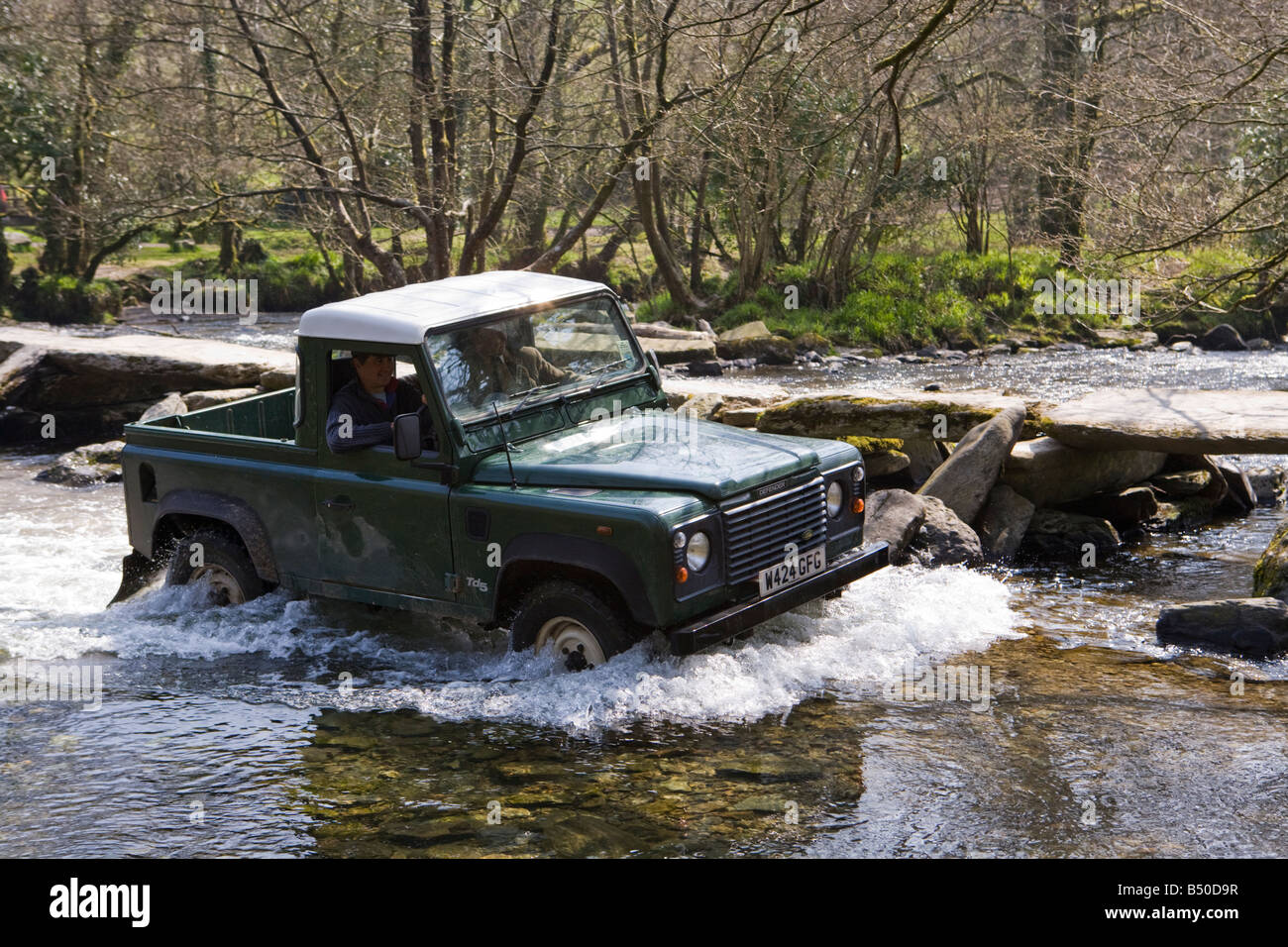 Land Rover Defender crossing the ford on the River Barle beside Tarr ...