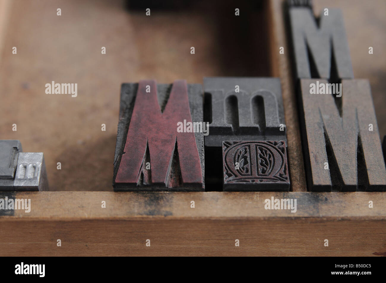 the letter M in different sizes and fonts in a wood type case, focus on ...