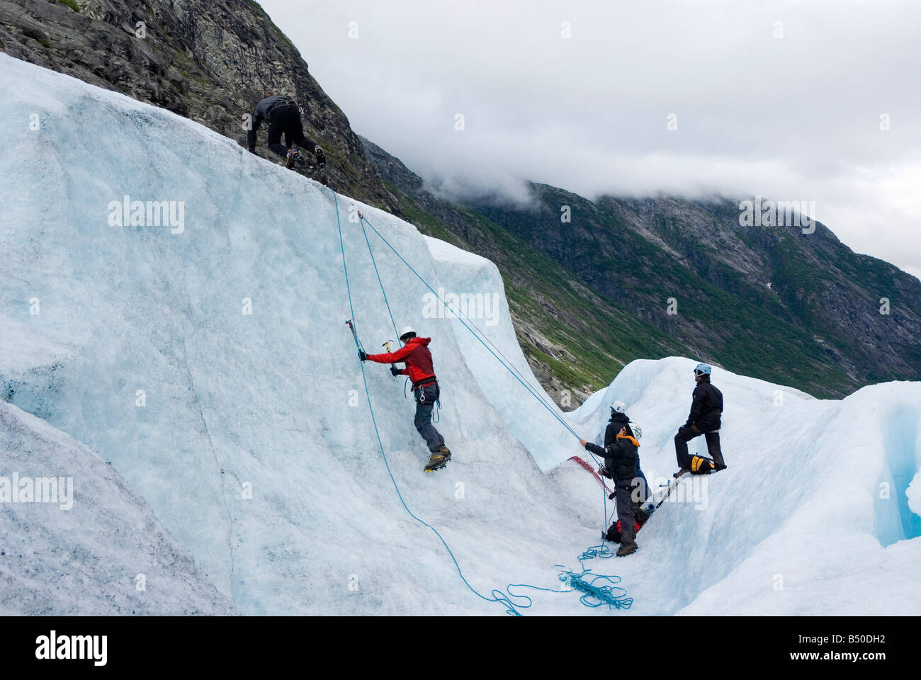 Instructor shows climbing technique to the beginners ice climbers Stock ...
