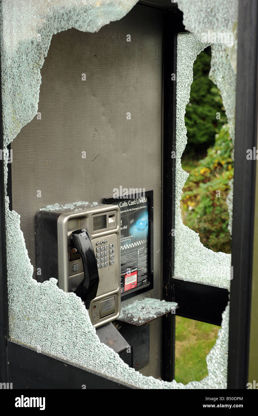 Smashed glass litters the interior of a British Telecom phone box after ...