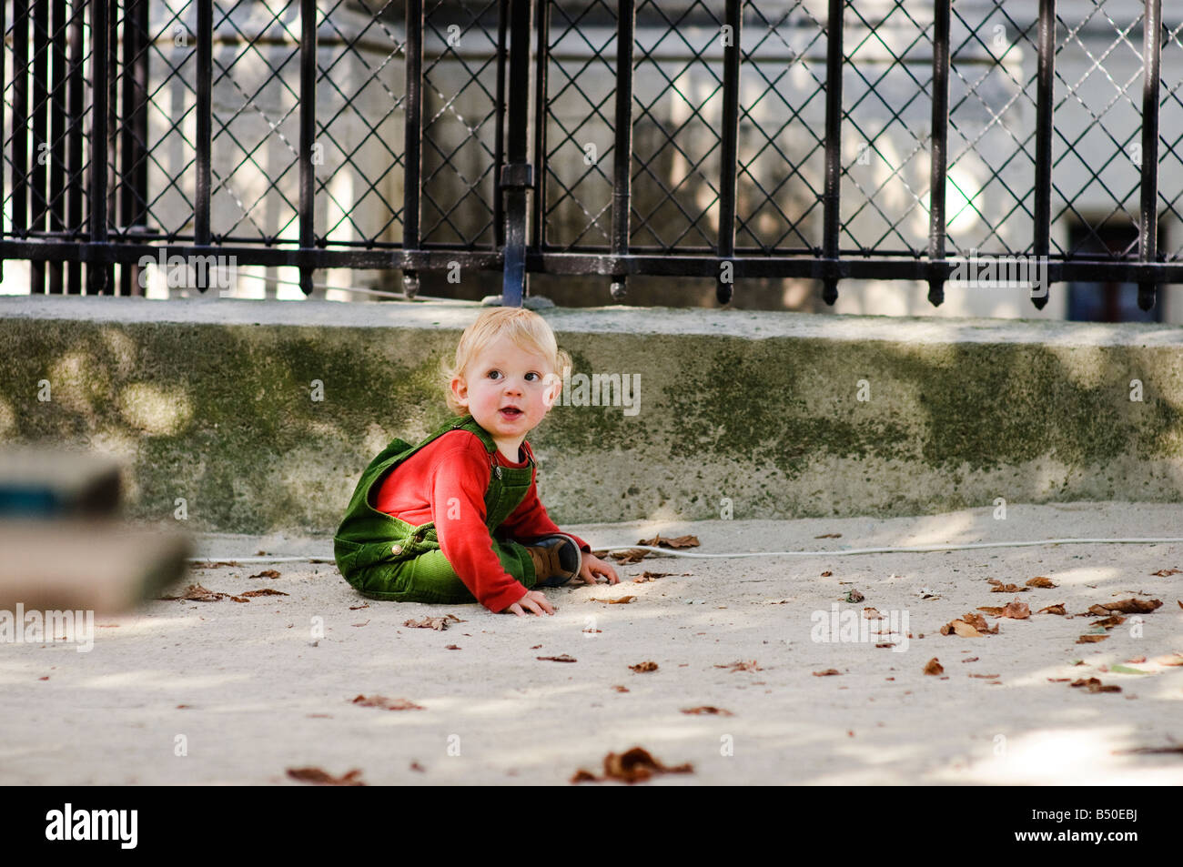 Young child sitting on the ground Stock Photo - Alamy