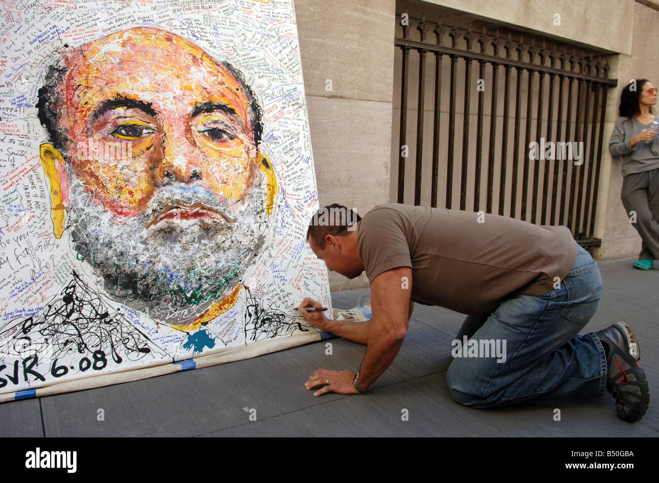 A passerby annotates a portrait of Federal Reserve Chairman Ben ...