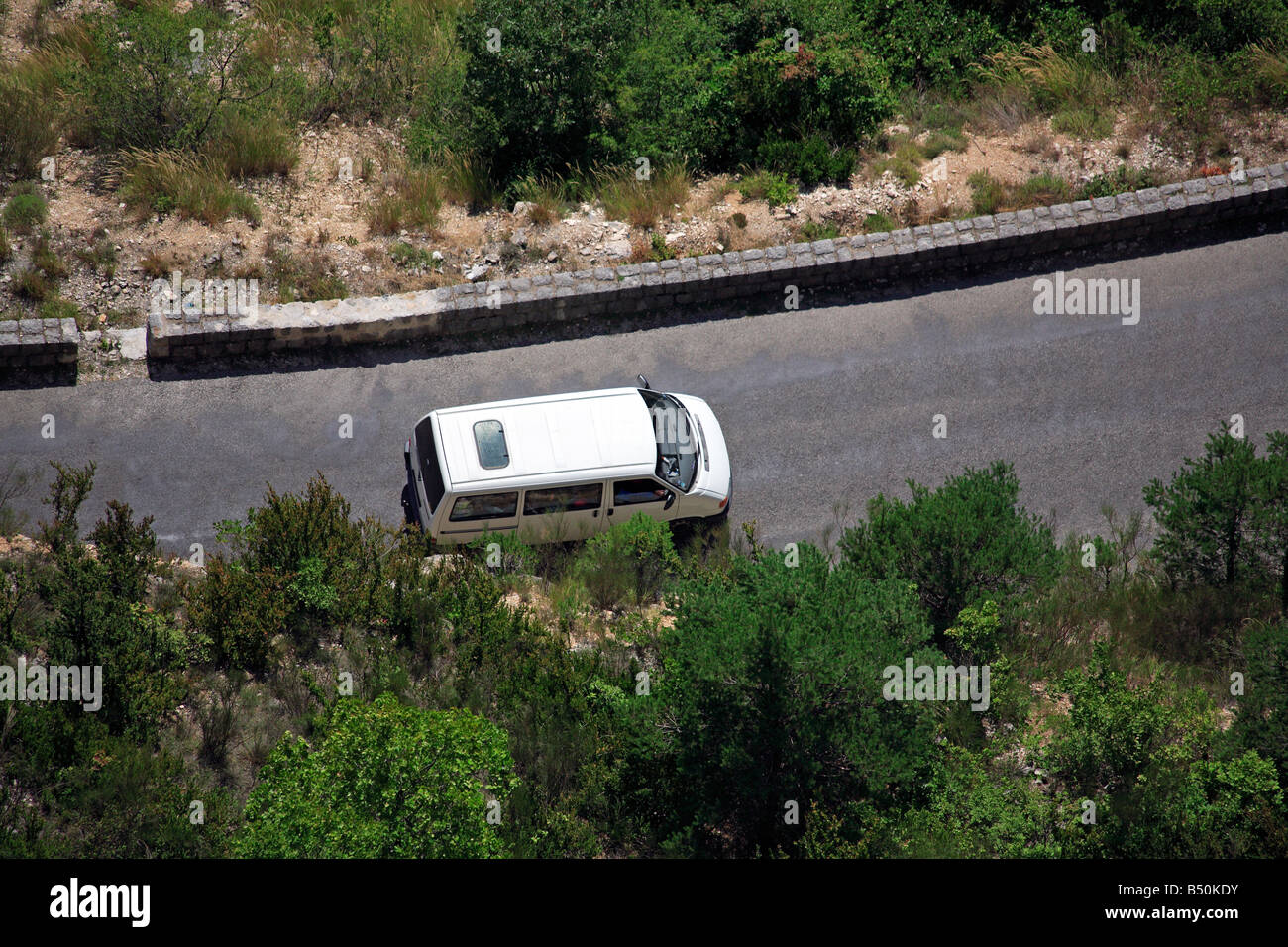 An aerial view of a white van driving on a winding road Stock Photo - Alamy