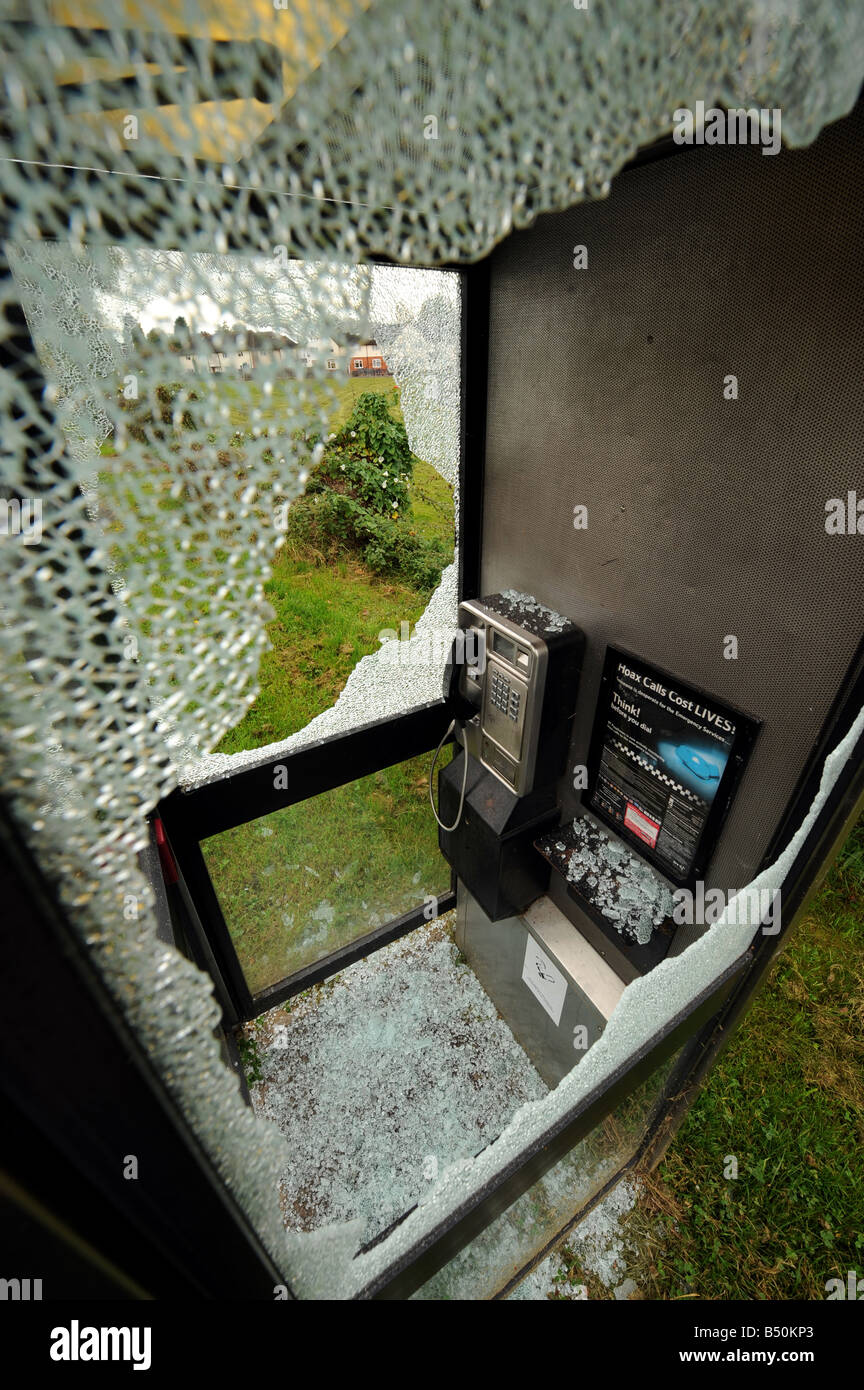 Smashed glass litters the interior of a British Telecom phone box after ...